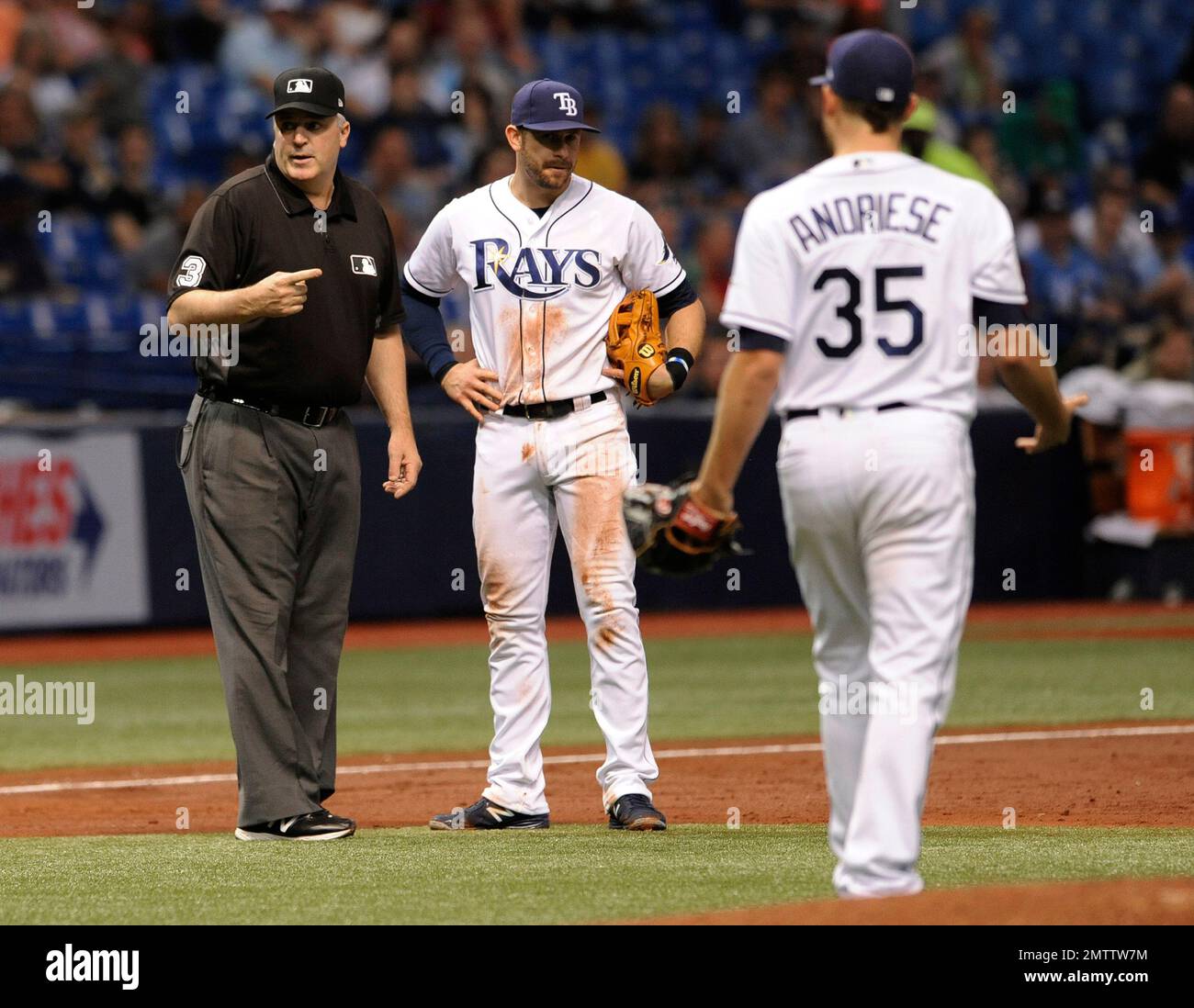 Tampa Bay Rays' Evan Longoria, center, looks on as umpire Bill Welke (3 ...