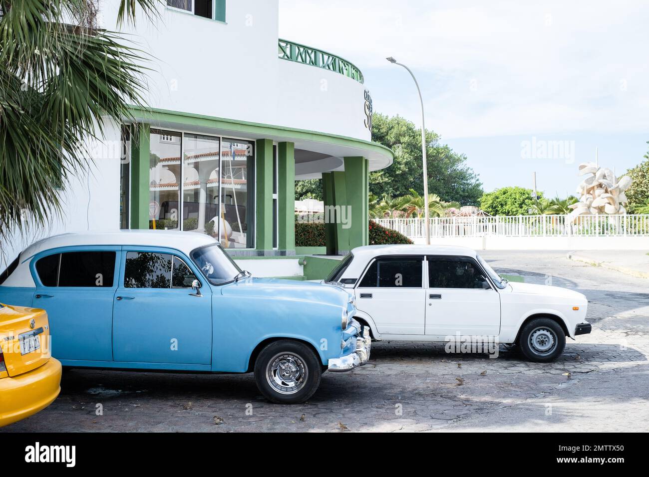 Classic cars parked outside an art deco style building in Varadero ...