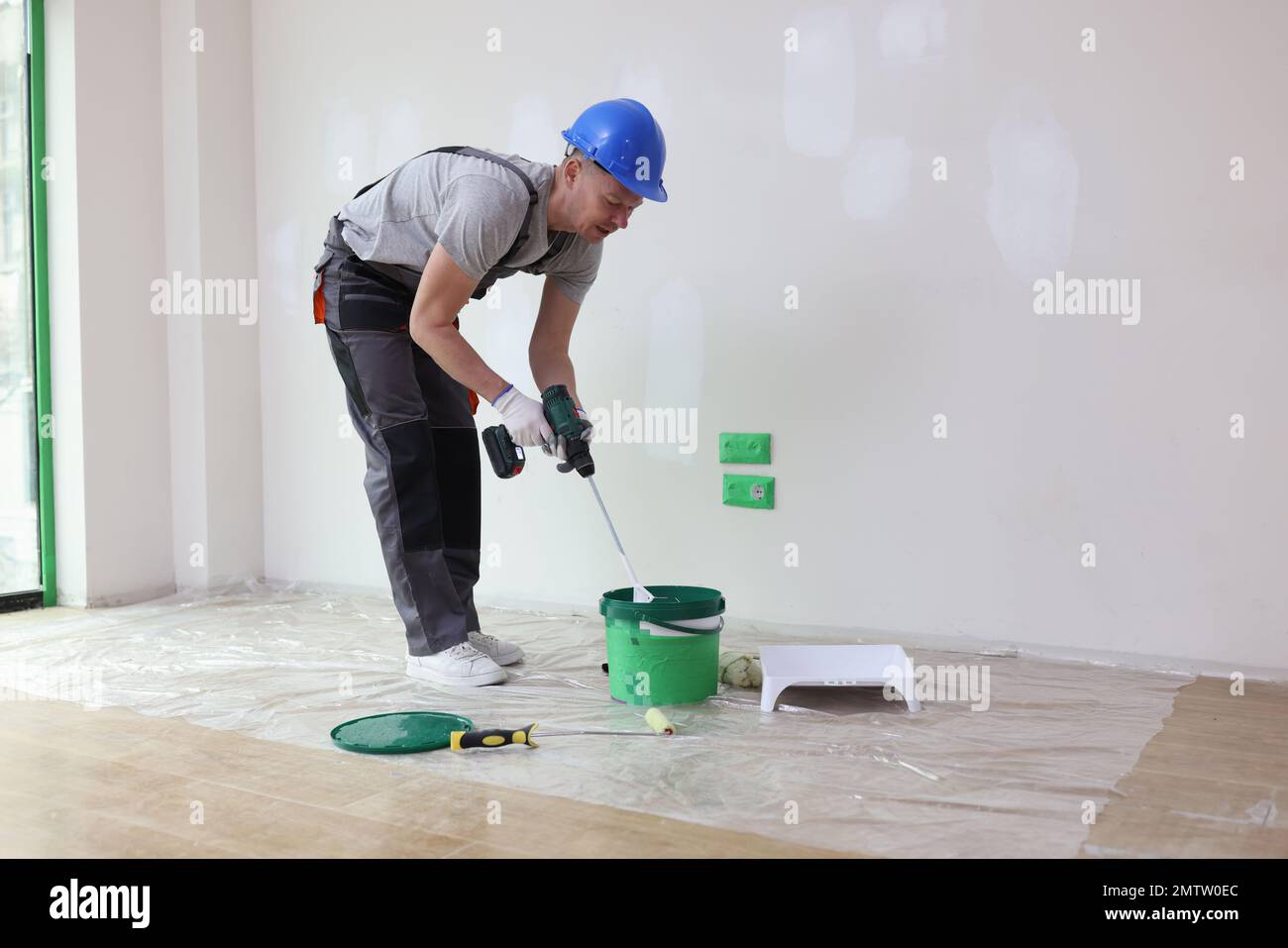 Construction worker mixes white paint hi-res stock photography and ...