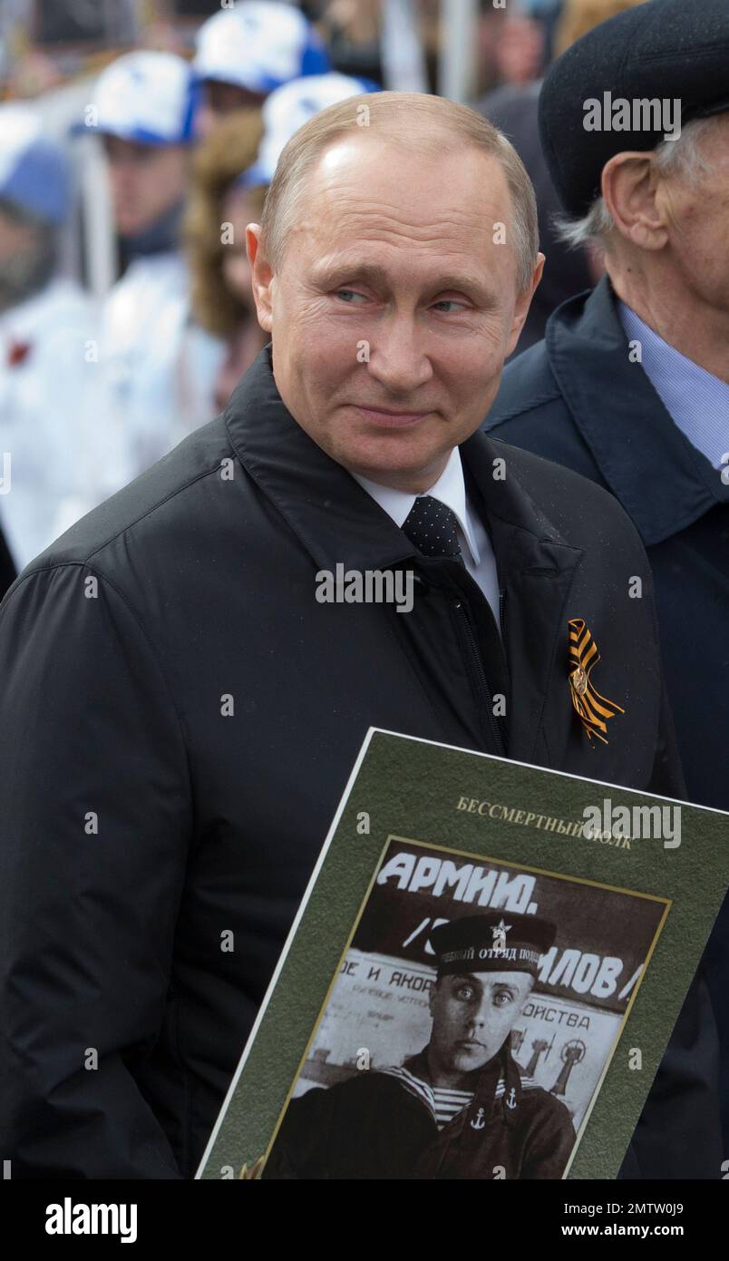 Russian President Vladimir Putin holds a photograph of his father in a ...