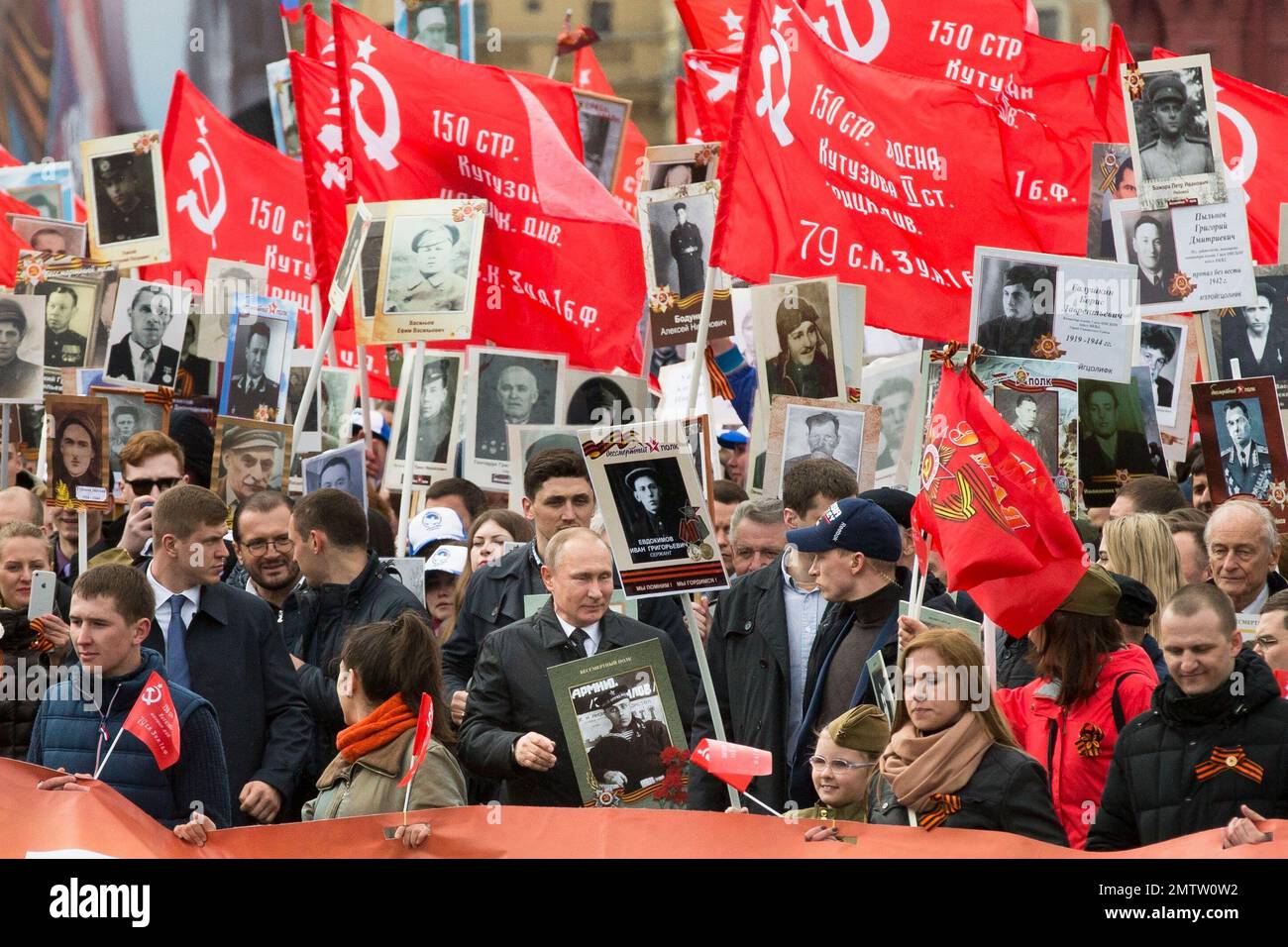 Russian President Vladimir Putin, center, holds a photograph of his ...