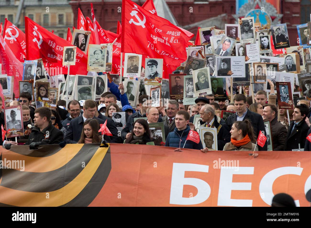 Russian President Vladimir Putin, center, holds a photograph of his ...