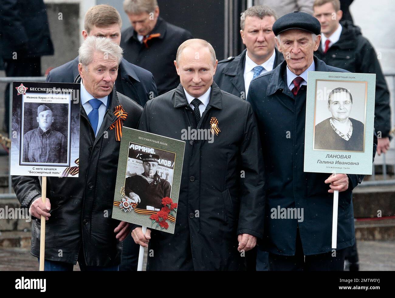 Russian President Vladimir Putin, center, holds a photograph of his ...