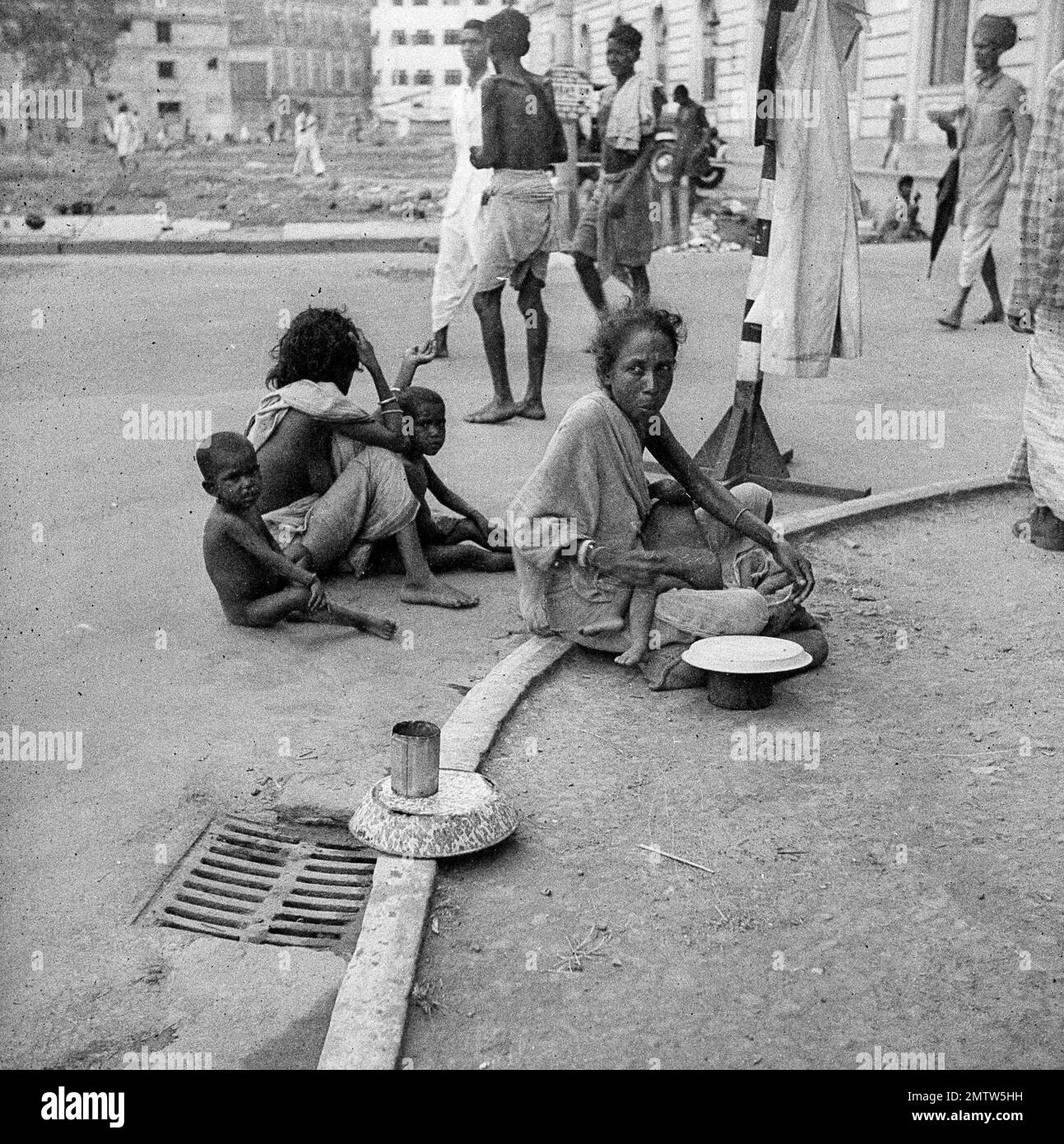 Two women with their three children sit dejectedly in a Calcutta street ...