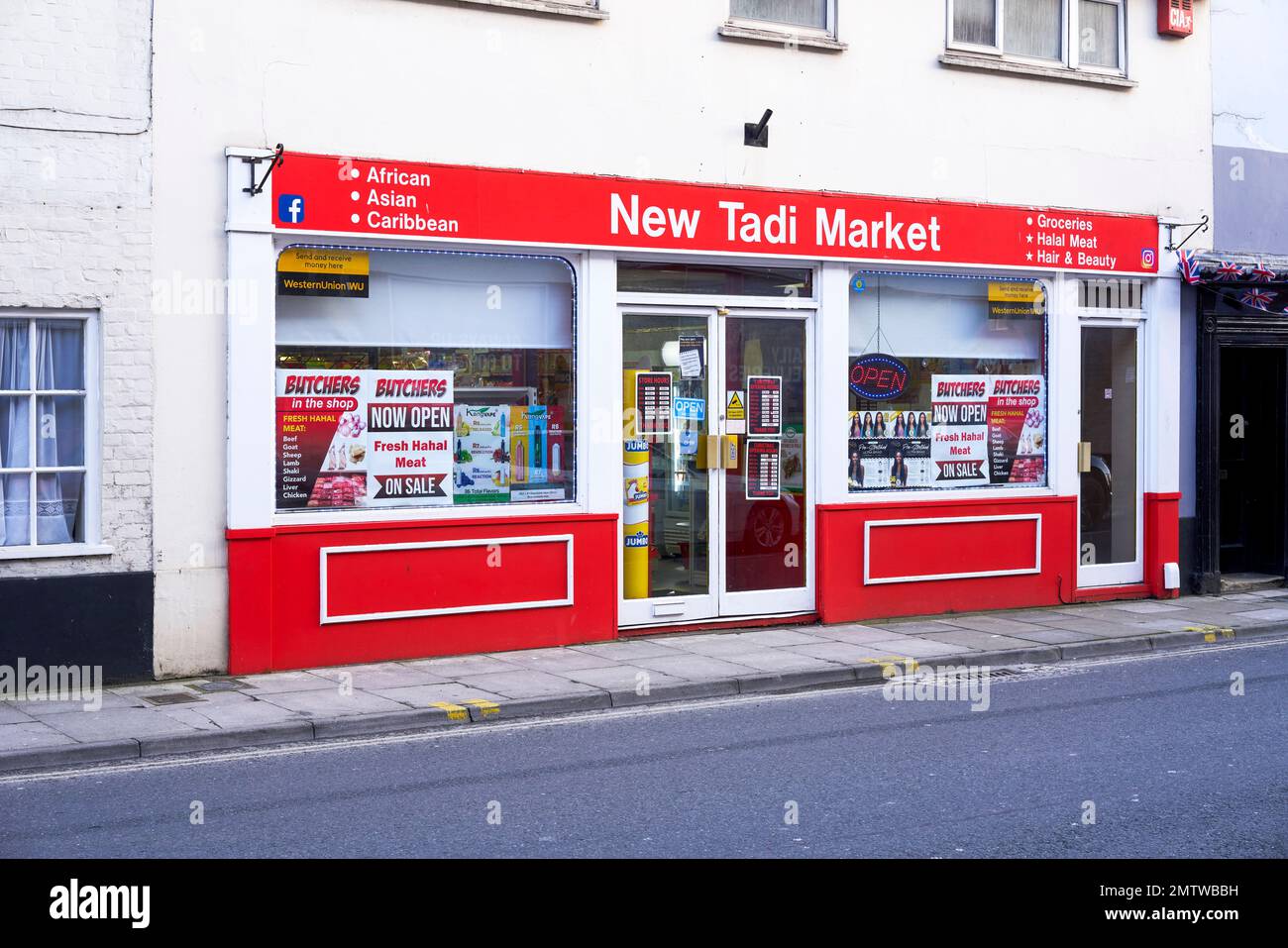 Brightly painted red and white shop selling African Asian and Caribbean ...