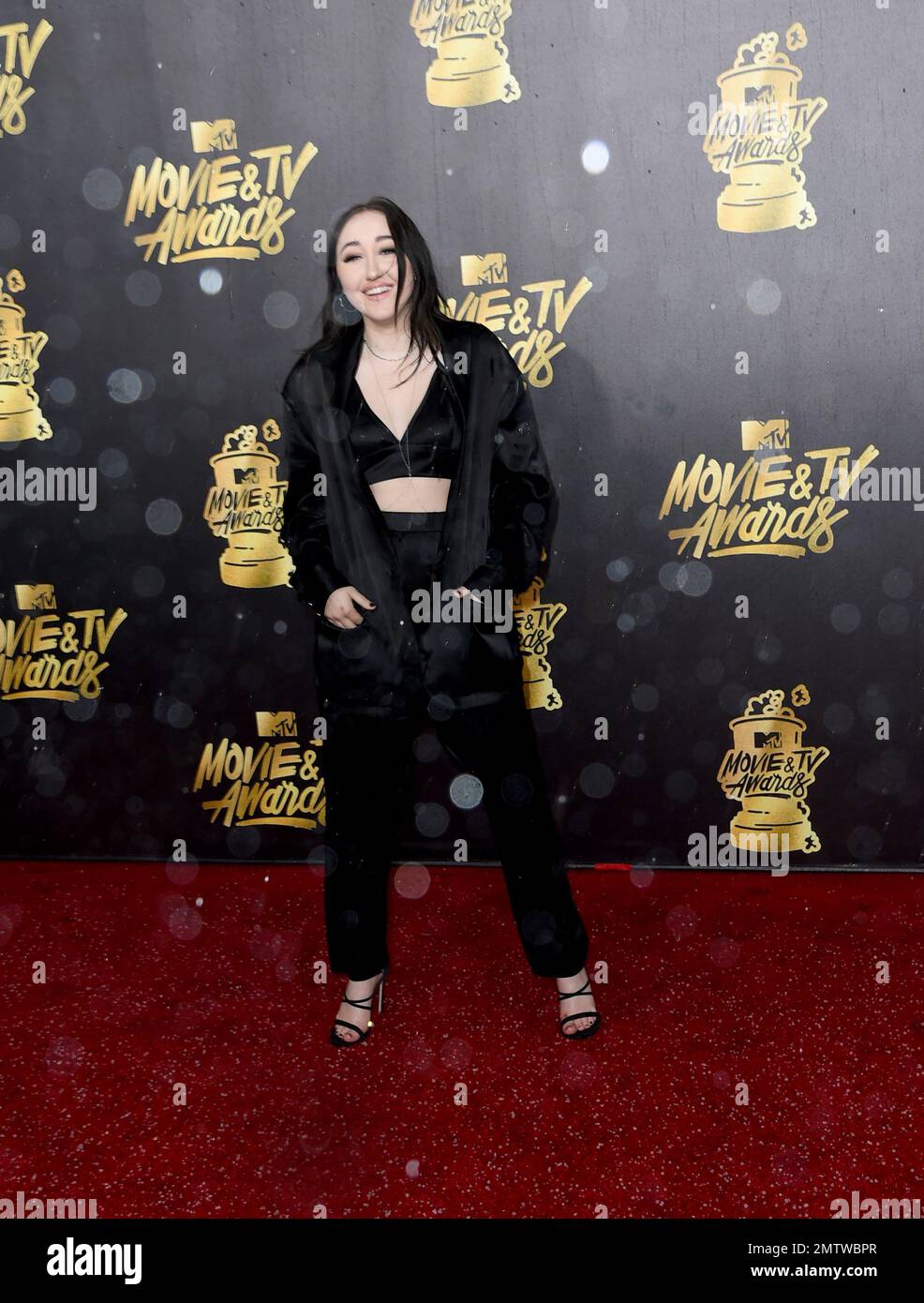 Noah Cyrus reacts during a rain and hail storm while arriving at the ...