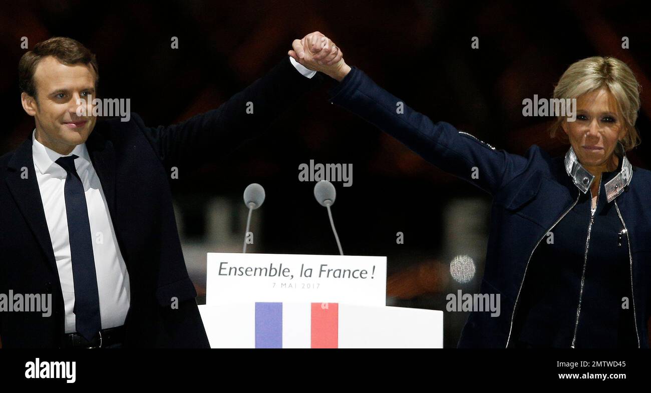 French President-elect Emmanuel Macron holds hands with his wife ...