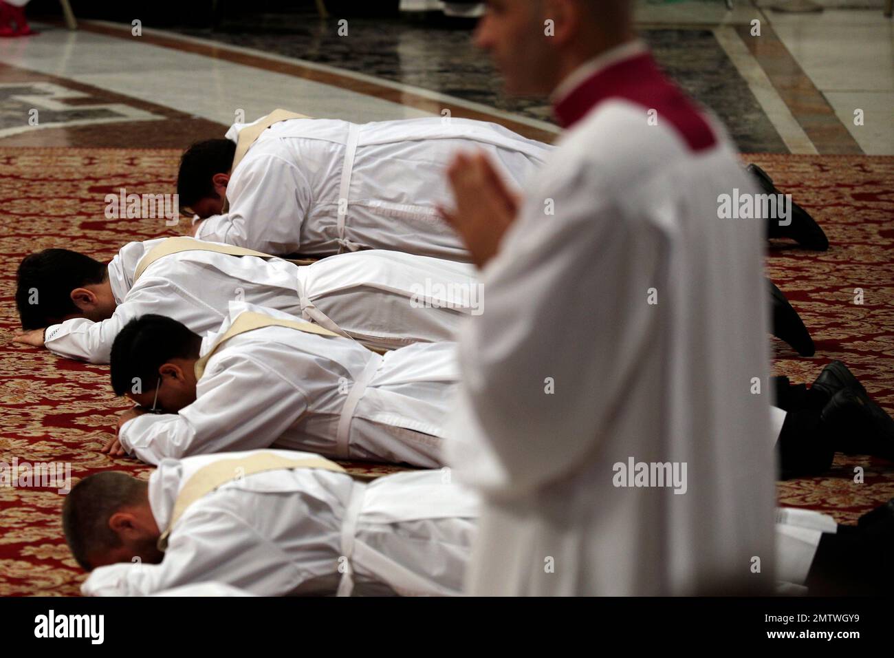 Ten new priests that were ordained by Pope Francis lay on the ground ...