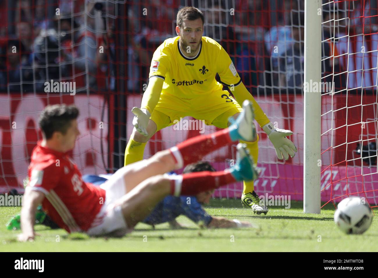 Darmstadt goalkeeper Michael Esser, background, watches the ball as ...