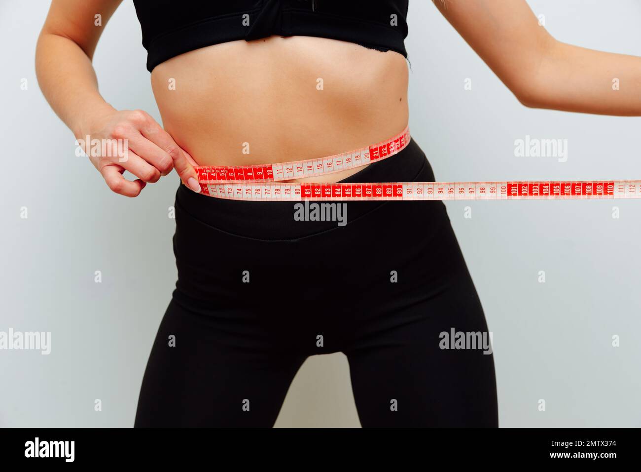 Slim woman measures her waistline with measuring tape. Healthy body ...