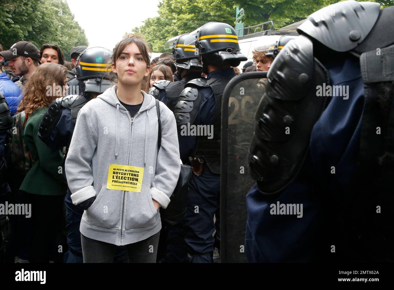 A high school student stands among riot police officers during a ...