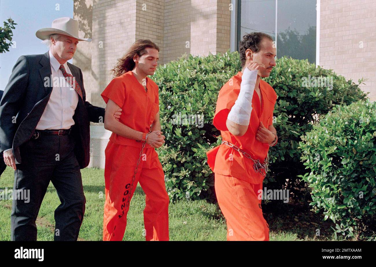 A law enforcement officer leads David Thibodeau, left, and Derek Lloyd Lovelock, survivors of ...
