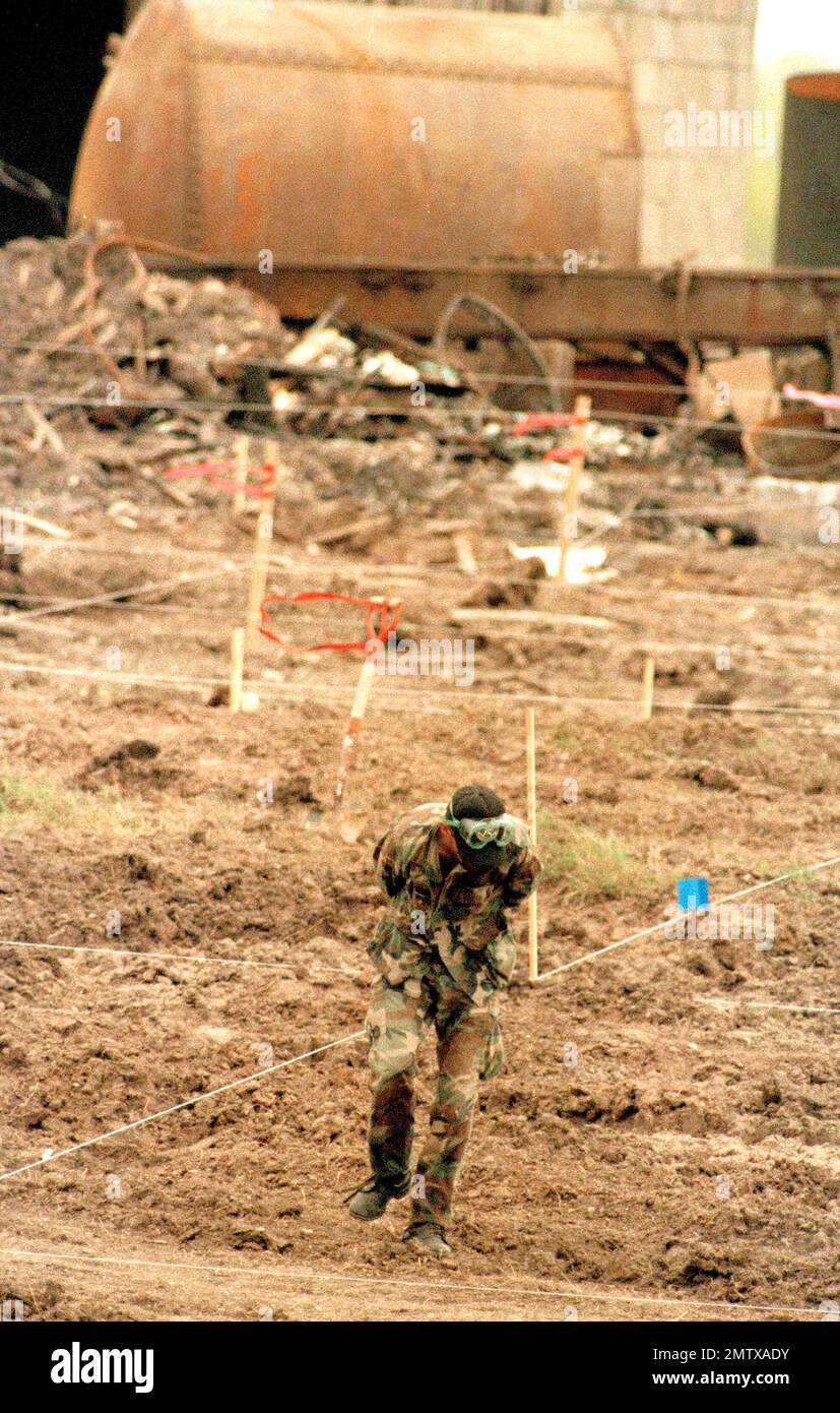 An investigator searches for evidence in the debris littering the ...