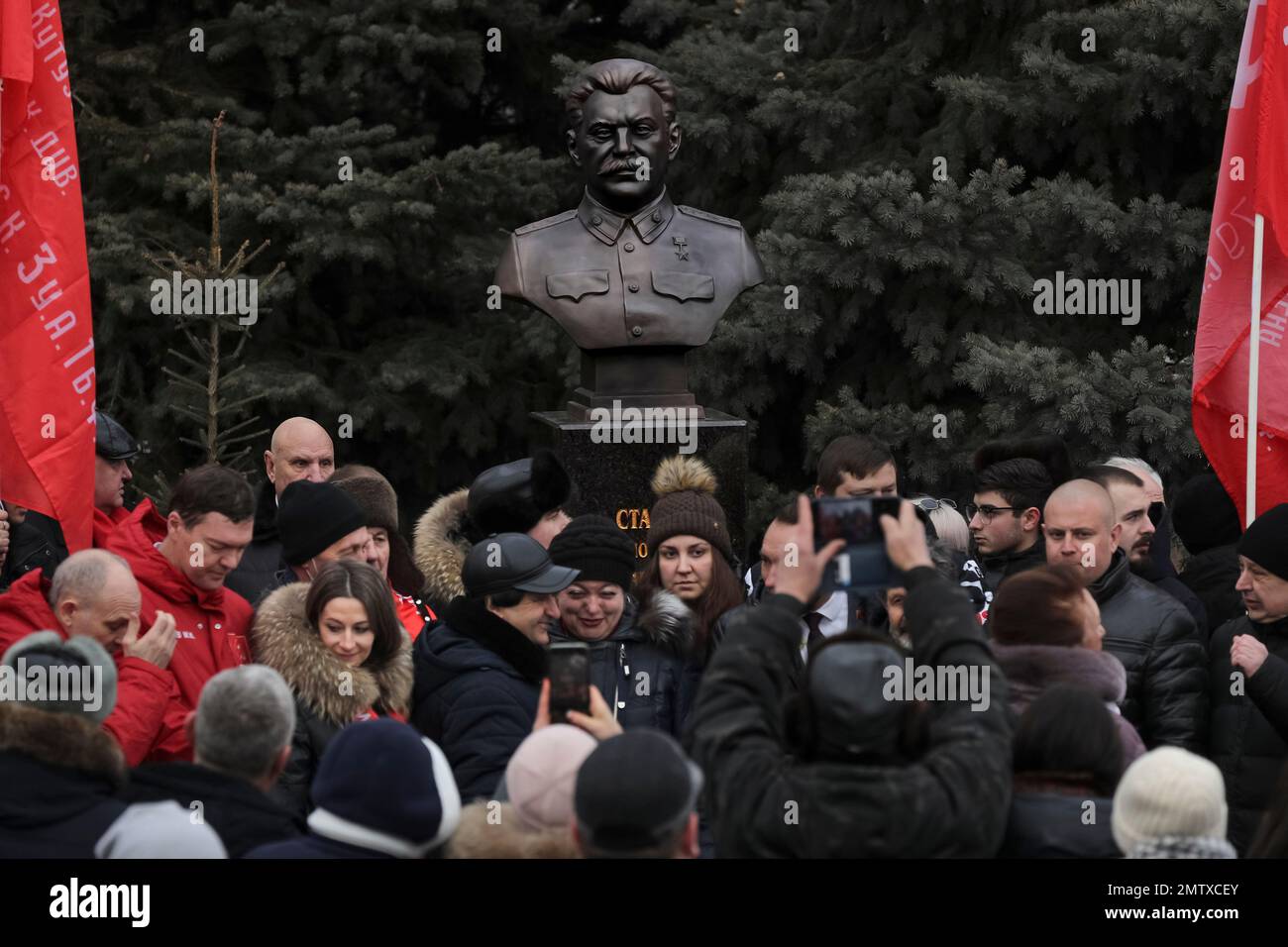 People take photos in front of the bust of Soviet leader Josef Stalin ...