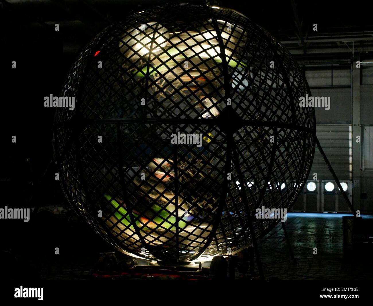 Two Motorcycle stunt riders perform within steel ball cage in the ...