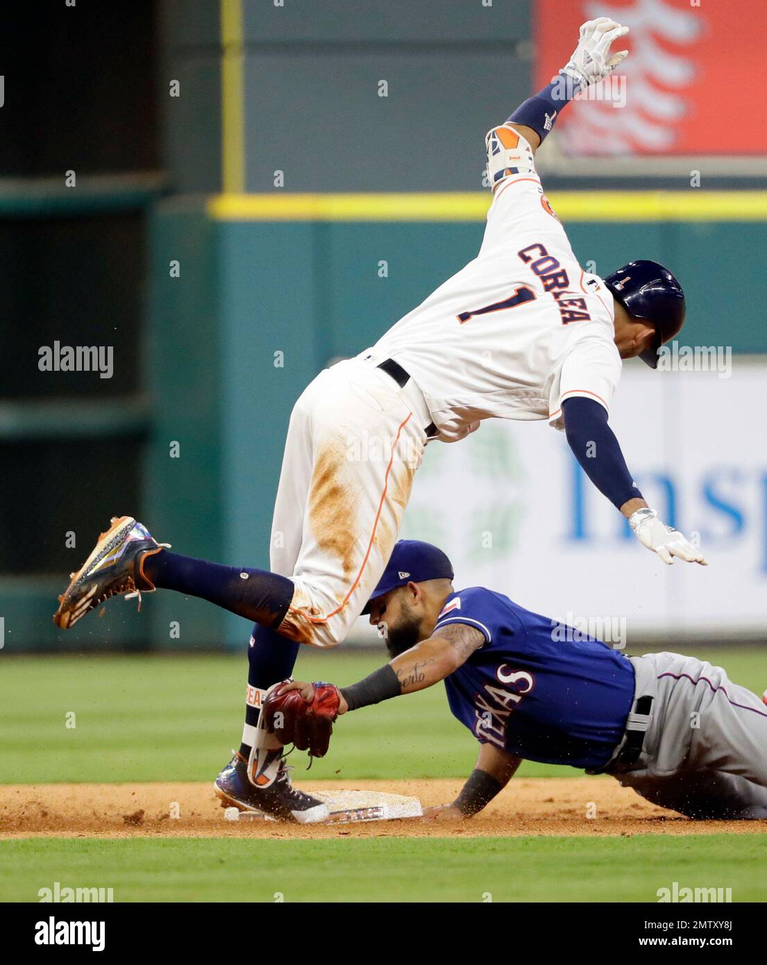 Houston Astros' Carlos Correa (1) avoids the tag of Texas Rangers ...