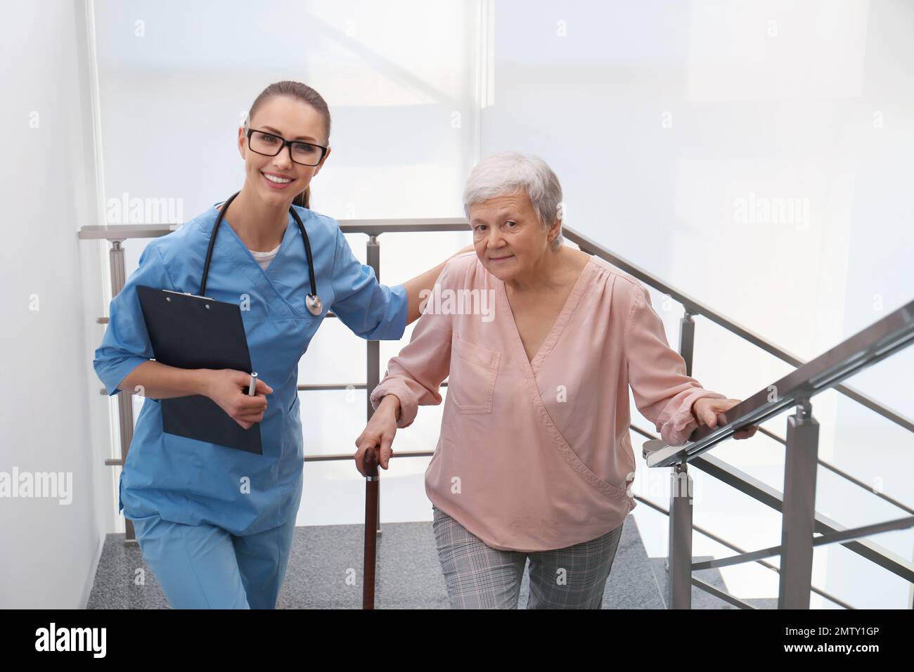 Doctor helping senior patient in modern hospital Stock Photo - Alamy