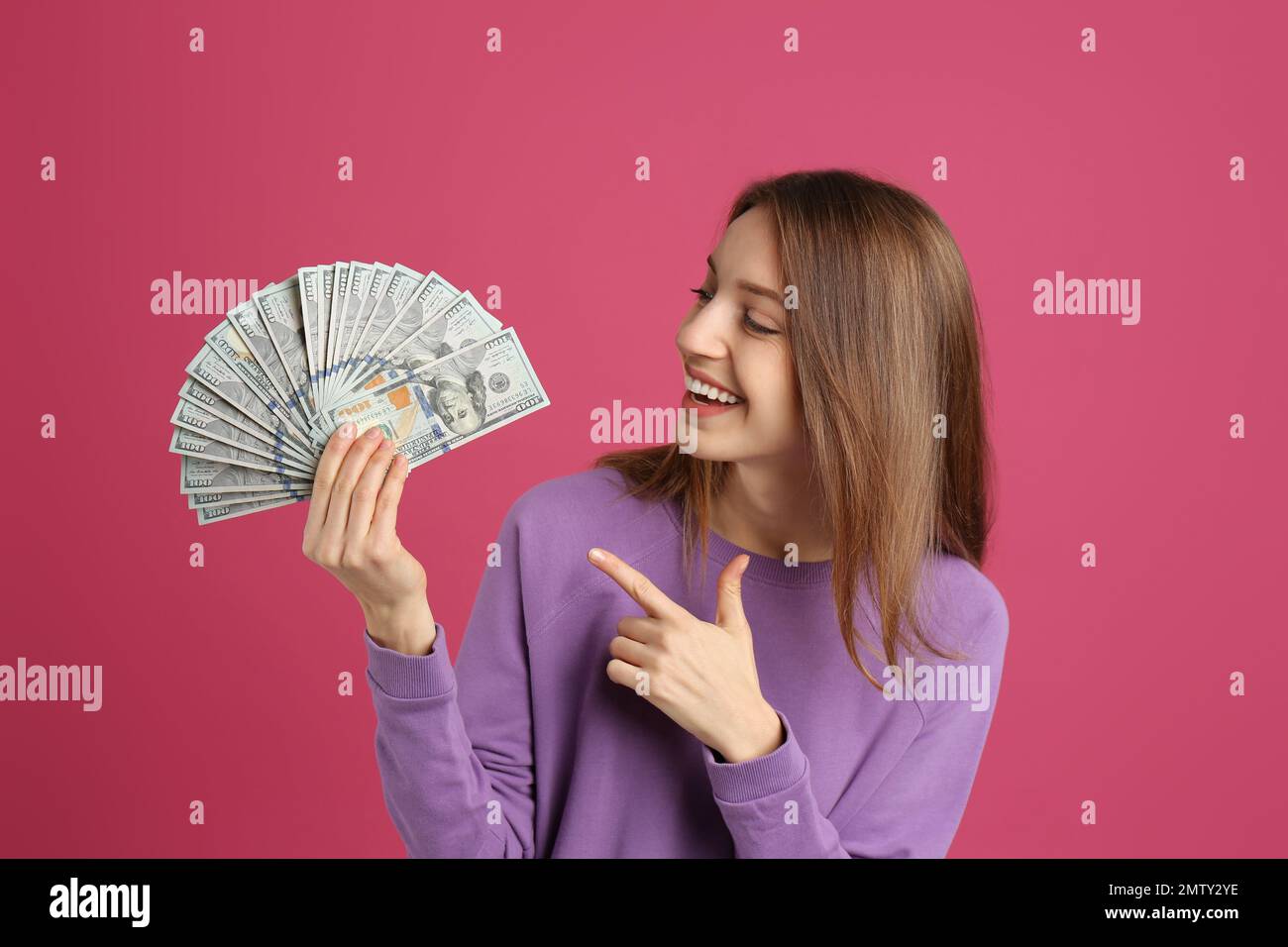 Happy young woman with cash money on pink background Stock Photo - Alamy