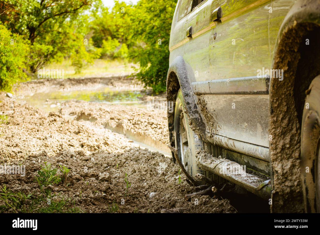 Close up view 4wd drive wheel spins through mud isolated stuck on ...