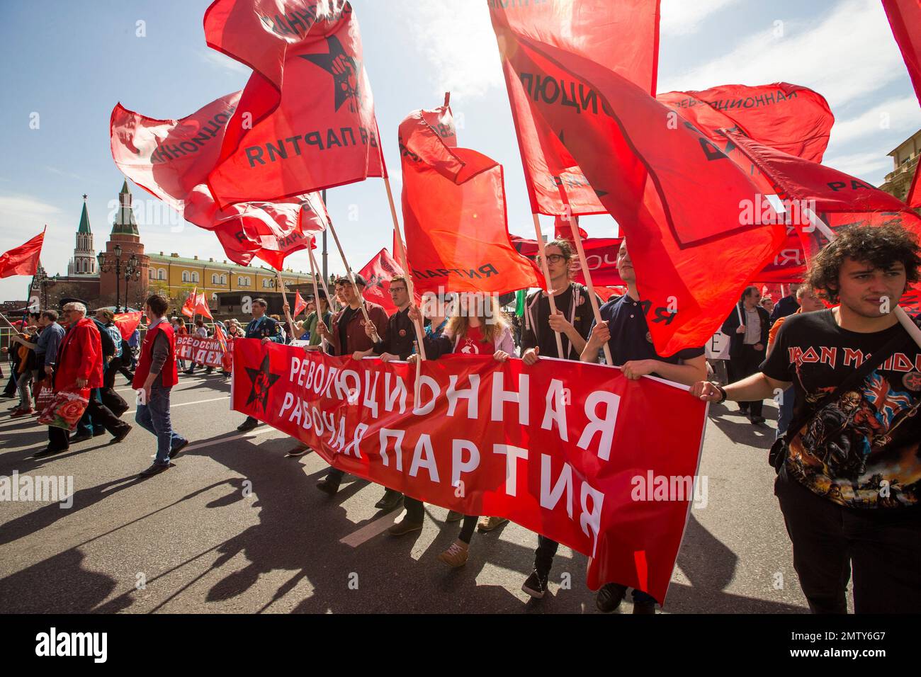 People march with red flags and a banner that reads 'Revolution Party ...