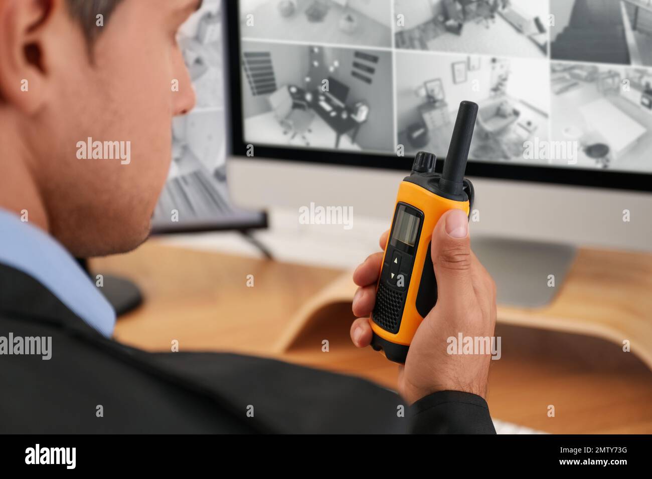 Male security guard with portable transmitter at workplace, closeup ...