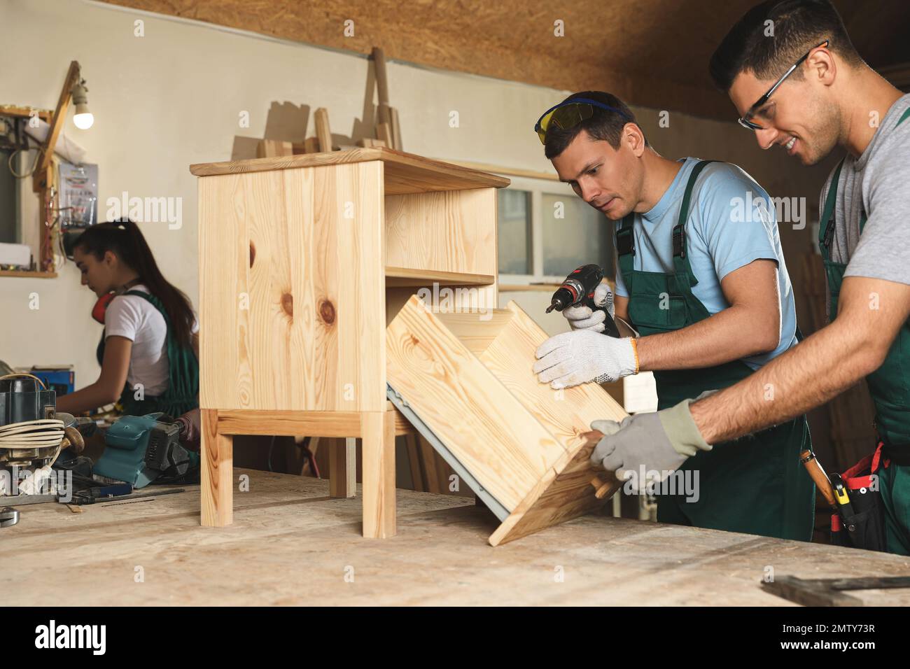 Professional carpenters assembling wooden cabinet in workshop Stock Photo - Alamy