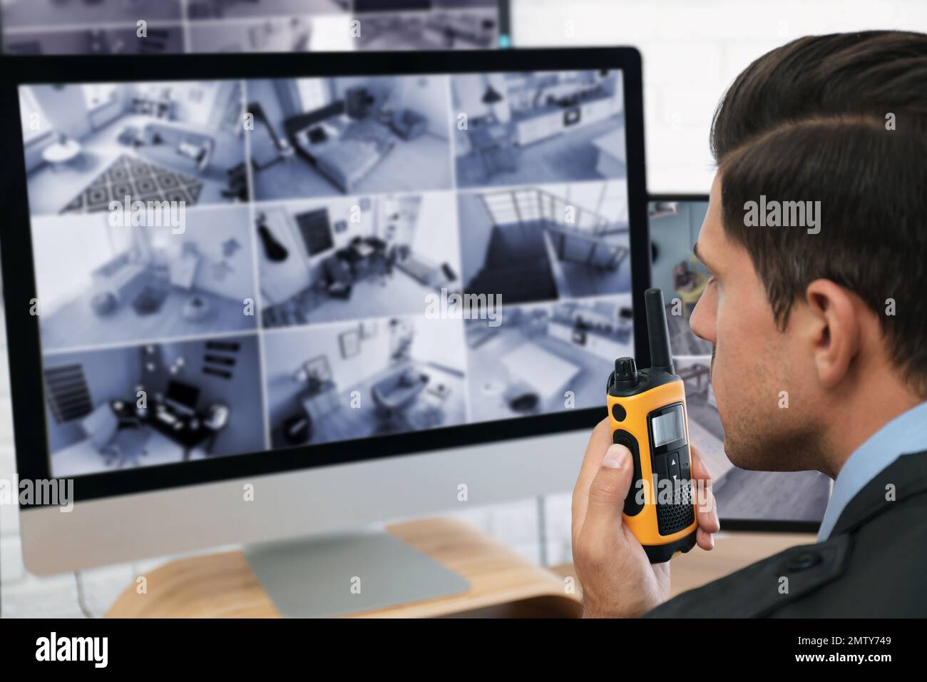 Male security guard with portable transmitter near monitors at ...