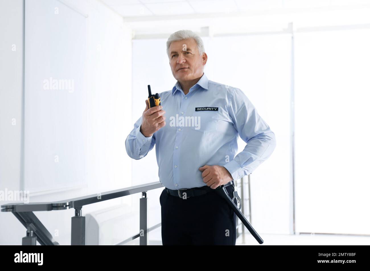 Professional security guard with portable radio set in office Stock ...