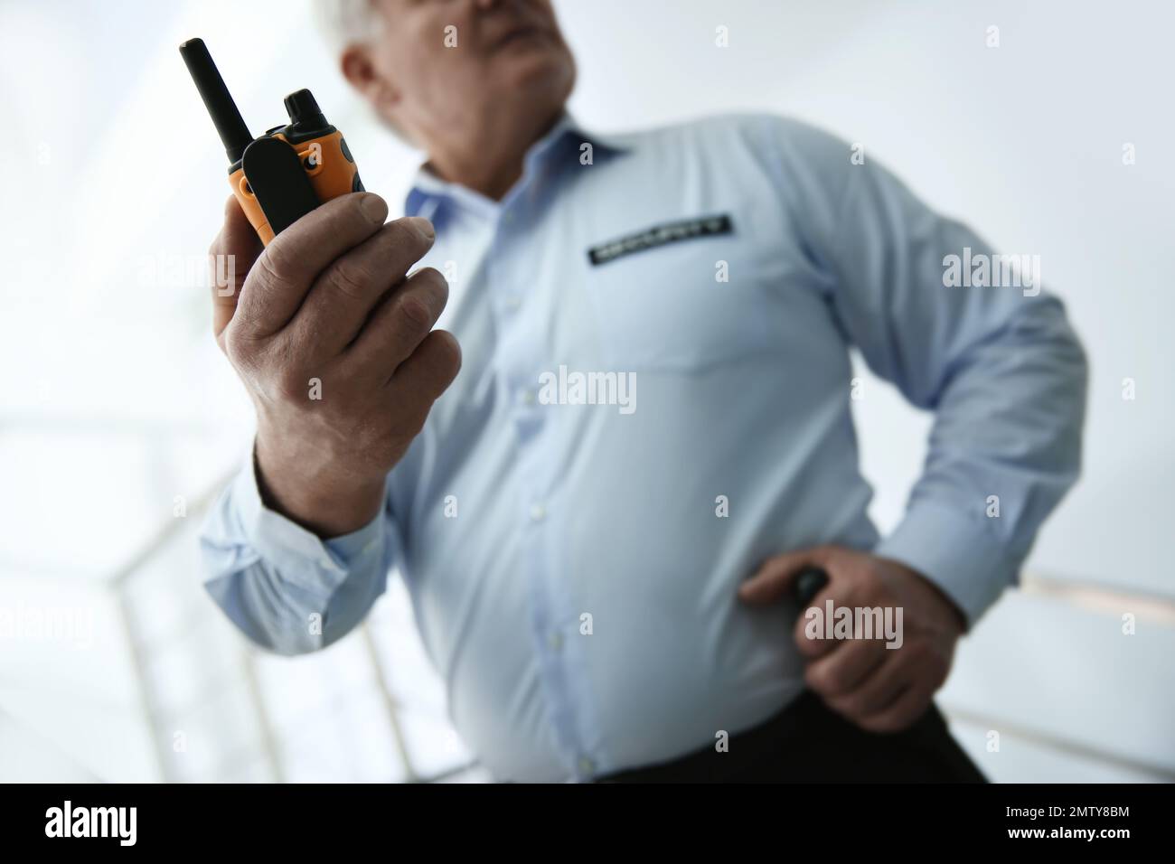 Professional security guard with portable radio set on stairs, closeup ...