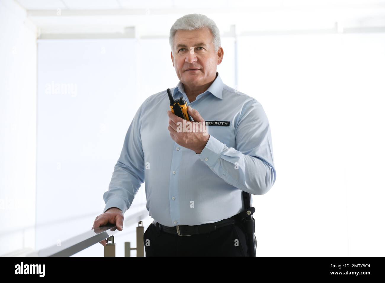 Professional security guard with portable radio set indoors Stock Photo ...