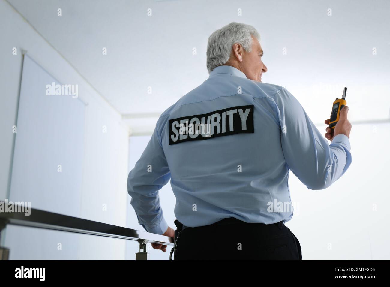 Professional security guard with portable radio set in office Stock ...