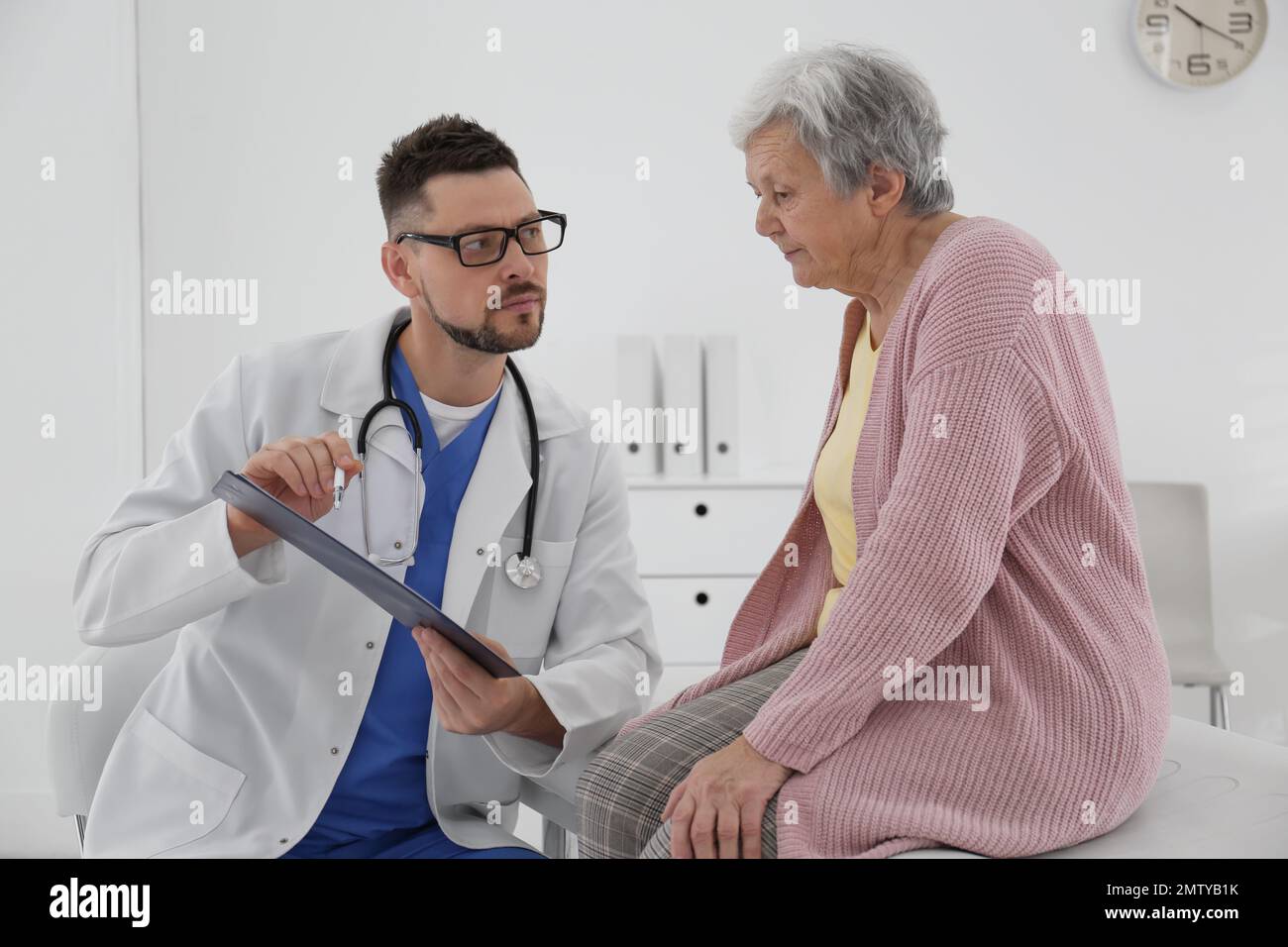 Doctor with senior patient in modern office Stock Photo - Alamy