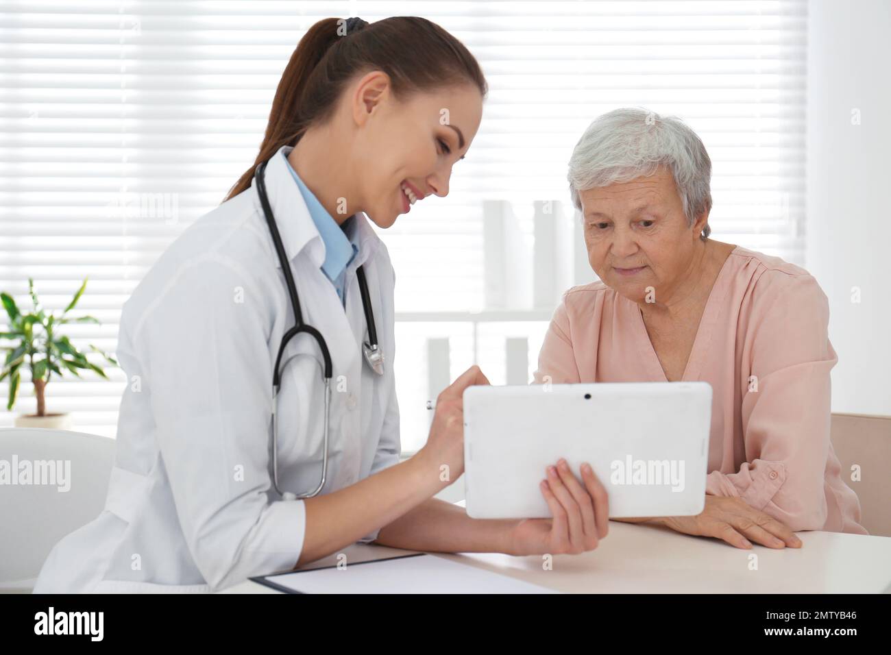 Senior woman visiting doctor in modern office Stock Photo - Alamy