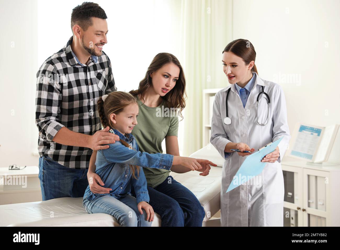 Parents and daughter visiting pediatrician. Doctor working with patient ...