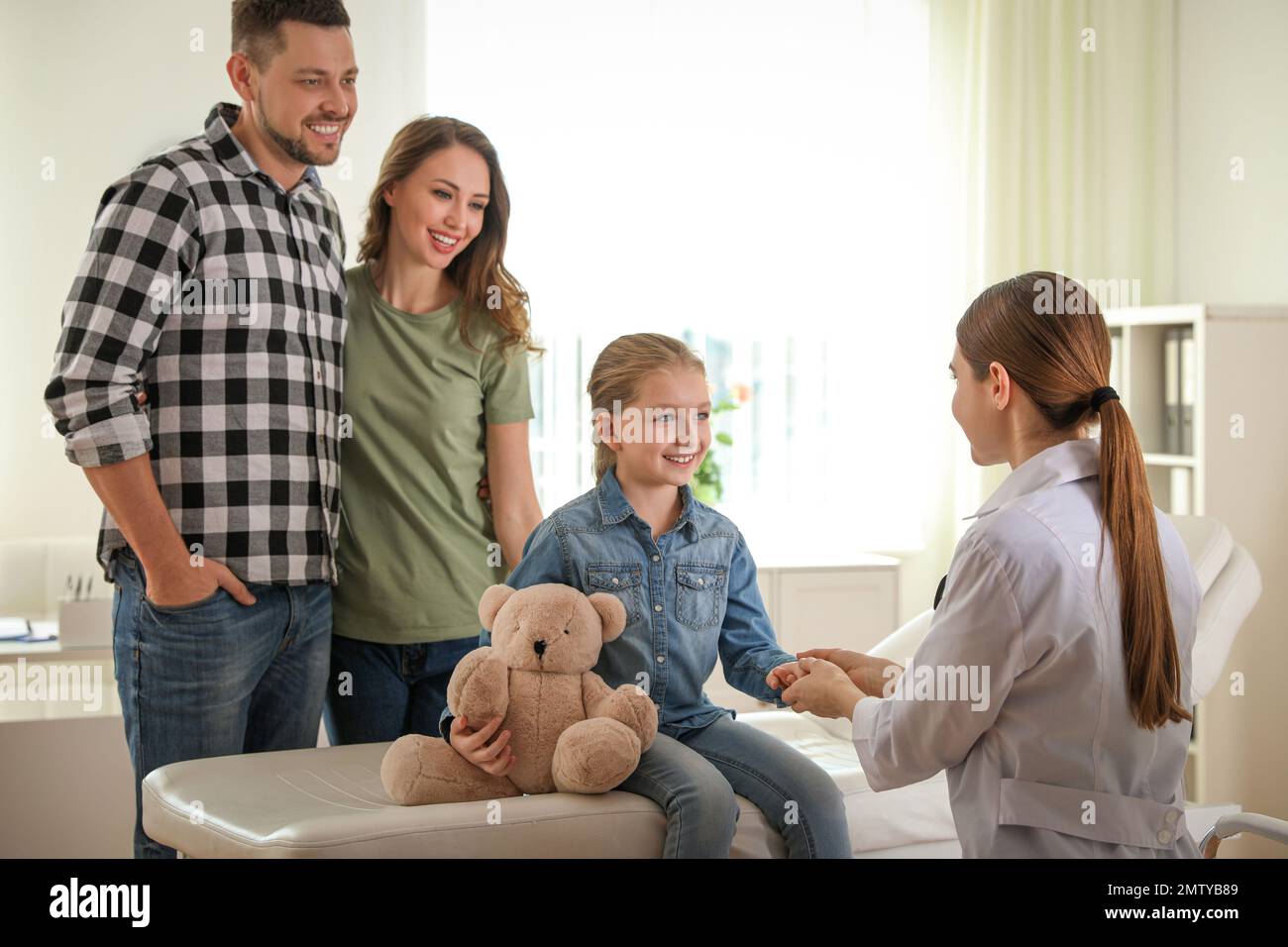 Parents and daughter visiting pediatrician. Doctor working with patient ...