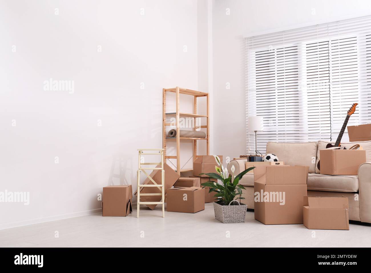Cardboard boxes and household stuff in living room. Moving day Stock ...