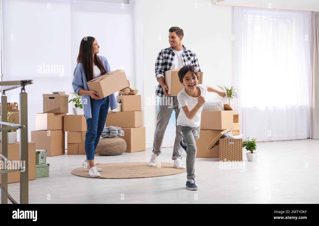 Happy family in room with cardboard boxes on moving day Stock Photo - Alamy