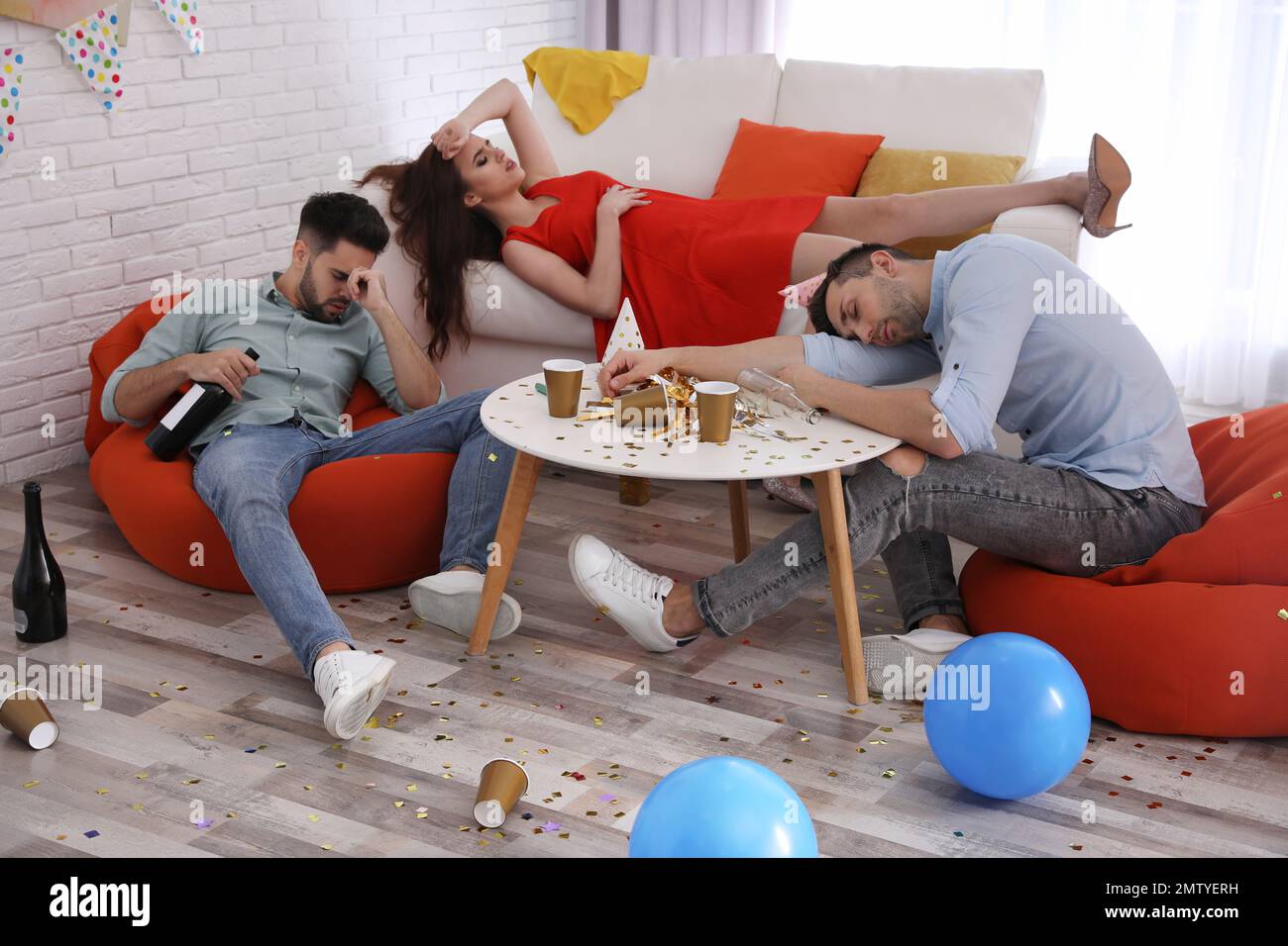 Friends suffering from hangover in messy room after party Stock Photo ...