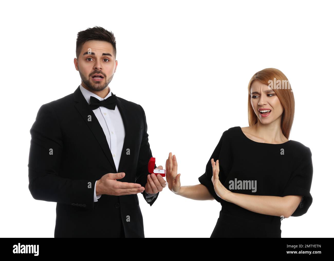 Young woman rejecting engagement ring from boyfriend on white ...