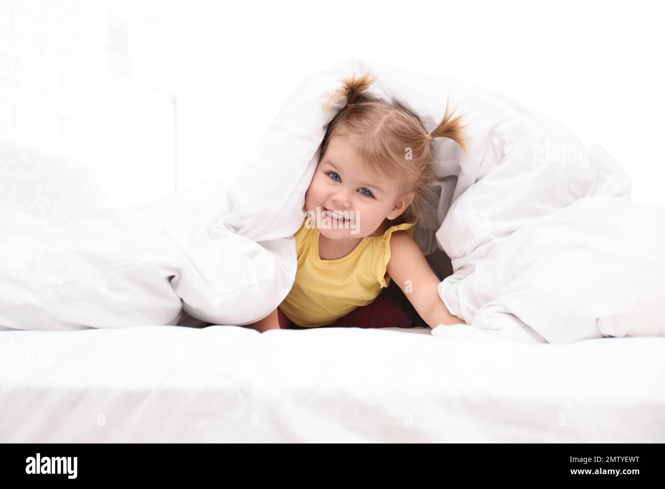 Cute little child playing under blanket in bed Stock Photo - Alamy