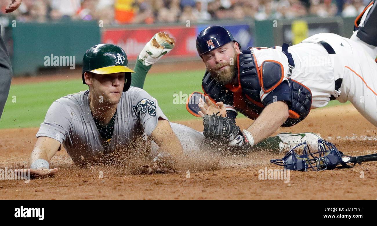 Oakland Athletics' Chad Pinder, left, is tagged out at home by Houston ...