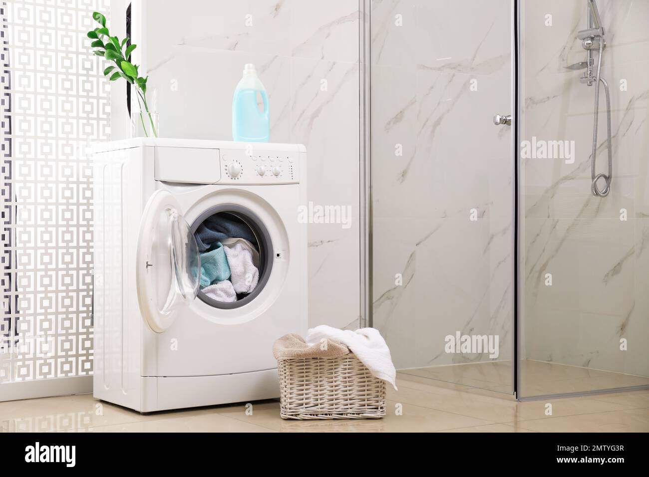 Modern washing machine with towels in bathroom Stock Photo - Alamy