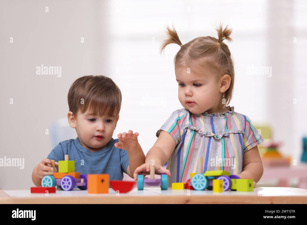 Cute little children playing with toys at table Stock Photo - Alamy