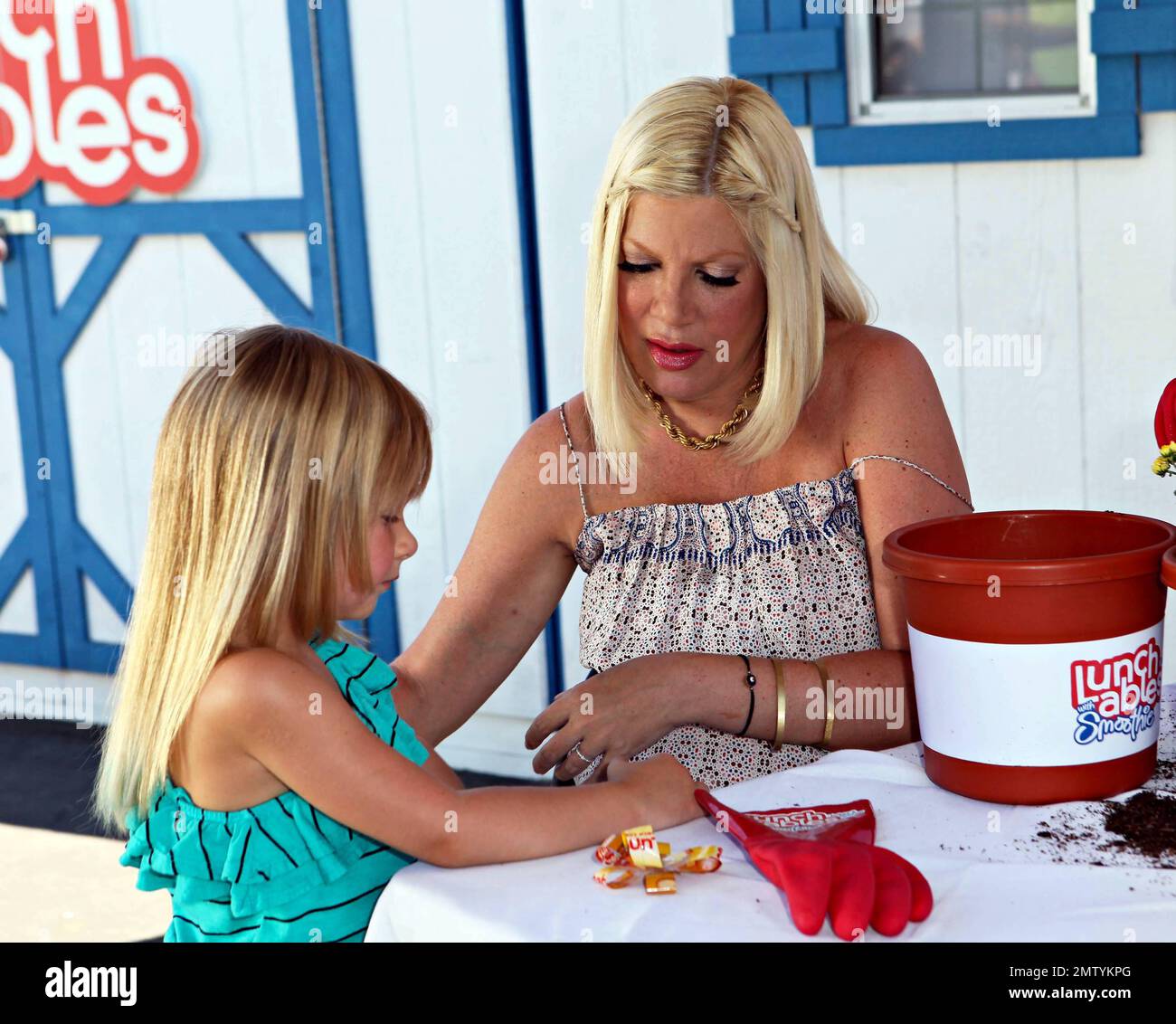 Tori Spelling plants flowers with her children Liam and Stella as ...