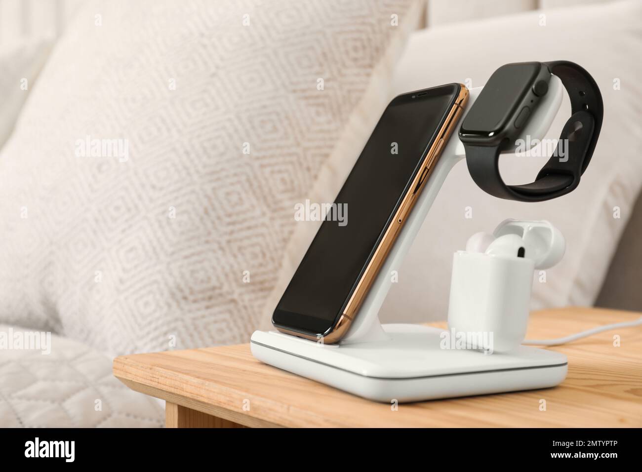 Different gadgets charging on wireless pad in bedroom, closeup Stock ...