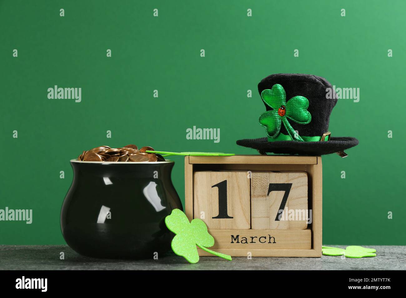 Composition pot of gold coins and wooden block calendar on grey stone ...