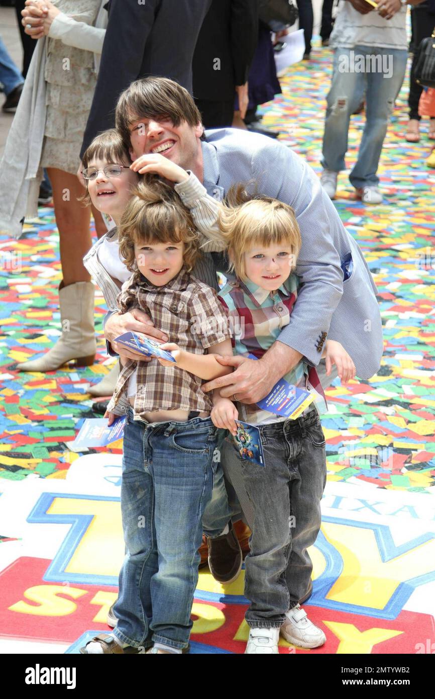 Blur bassist Alex James gives a big smile and hugs his sons Geronimo ...