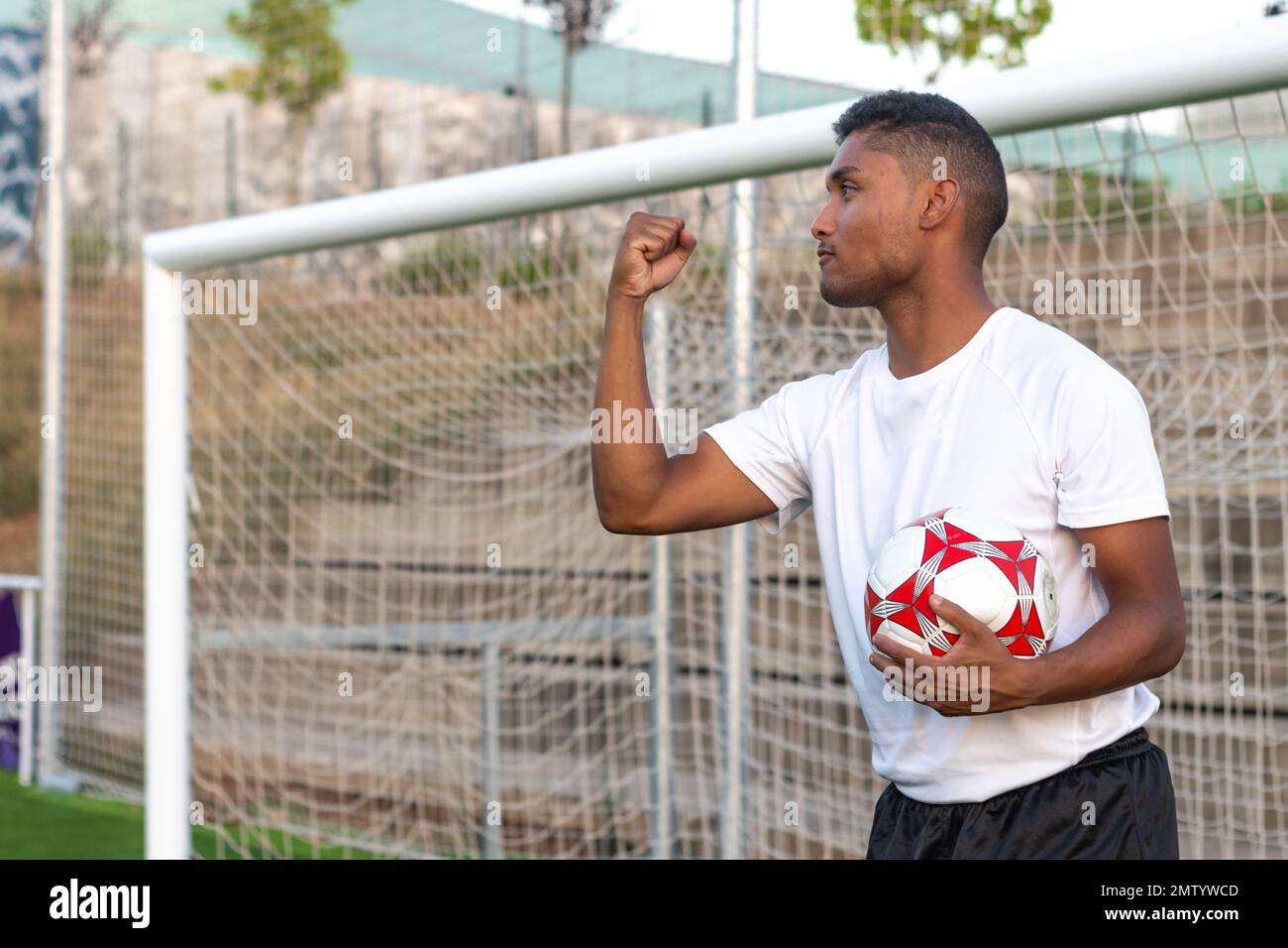A young Hispanic soccer player with the ball in hand celebrating the ...