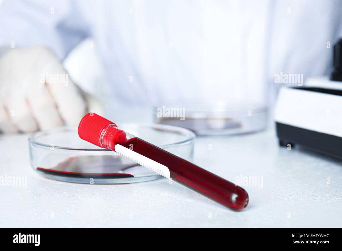 Scientist working in laboratory, focus on test tube and Petri dish with ...