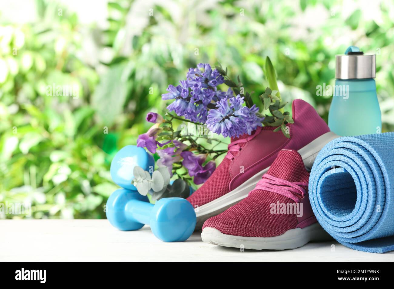 Composition with spring flowers and sports items on blurred green ...